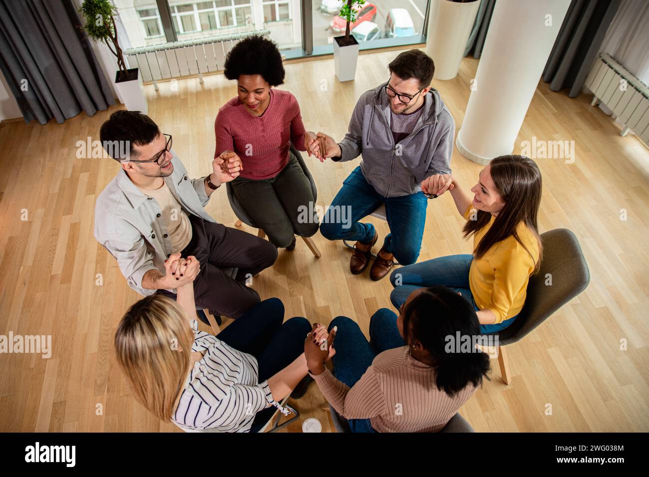 Diverse group of people sitting in circle in group therapy session ...