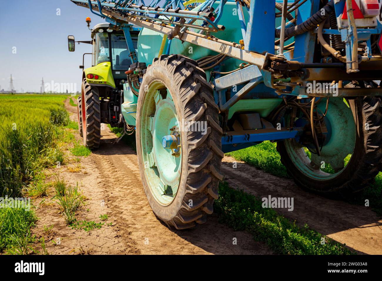 Low angle view of tractor as dragging mounted wide agricultural sprayer ...