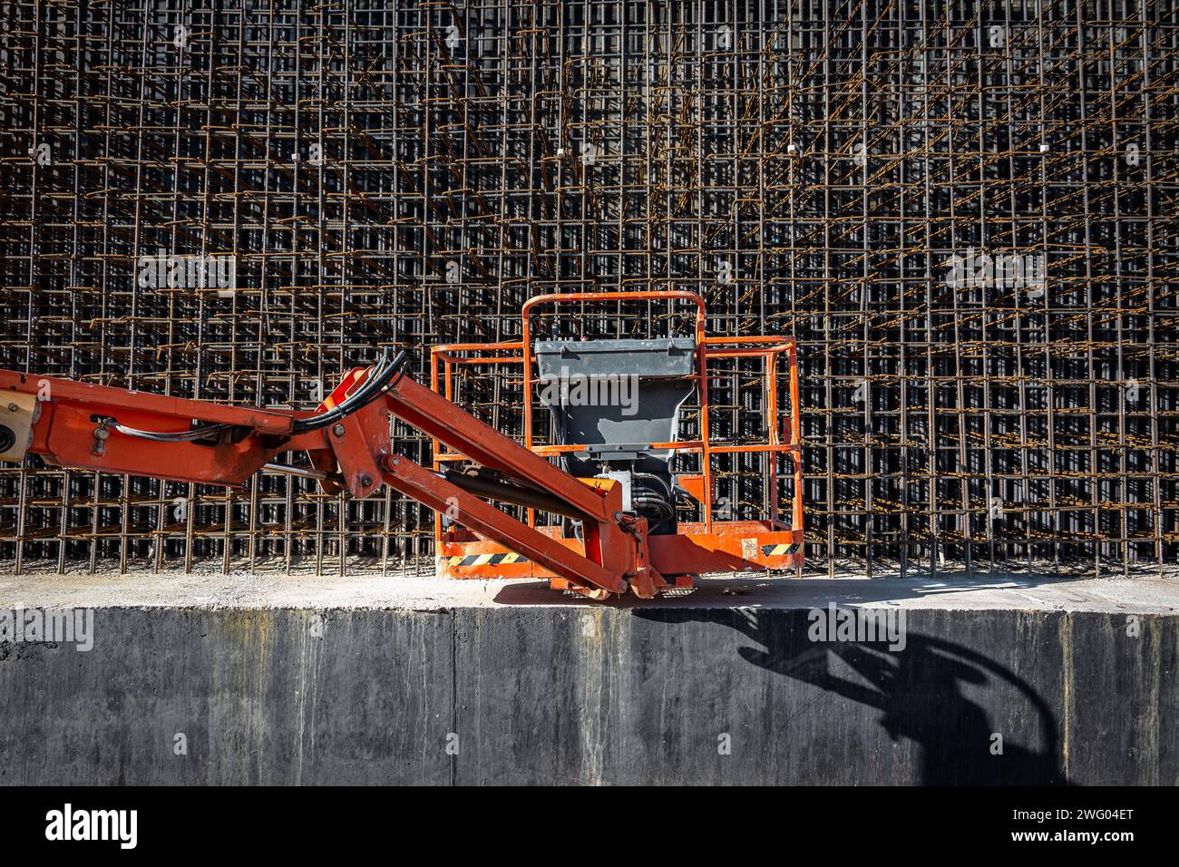 A red work platform with a machine leaning over Stock Photo - Alamy