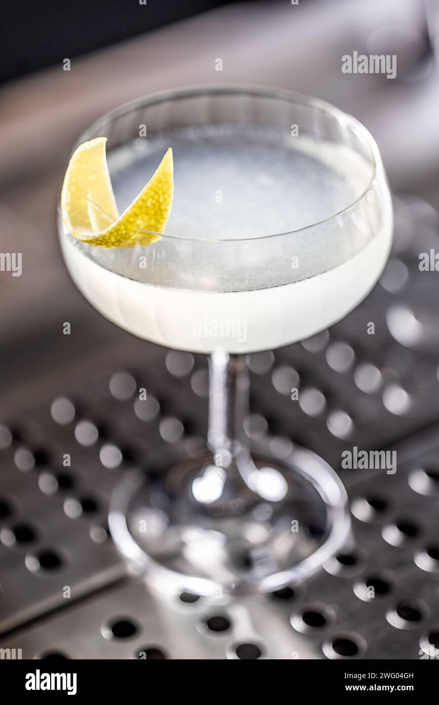 Refreshing French cocktail 75 decorated with lemon peel in a glass at ...