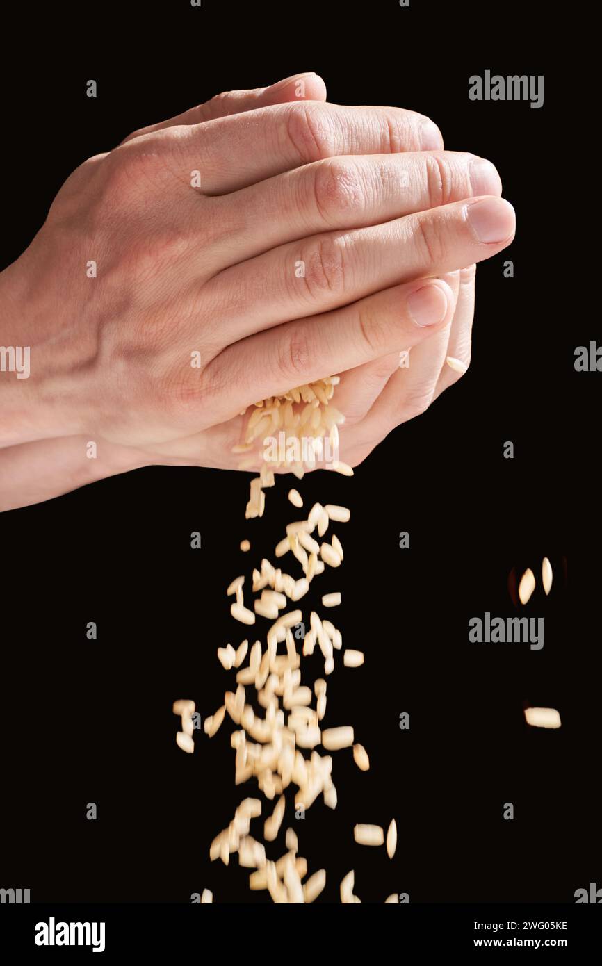 A hands hold a pile of rice, symbolizing charity, love, and hope. With ...