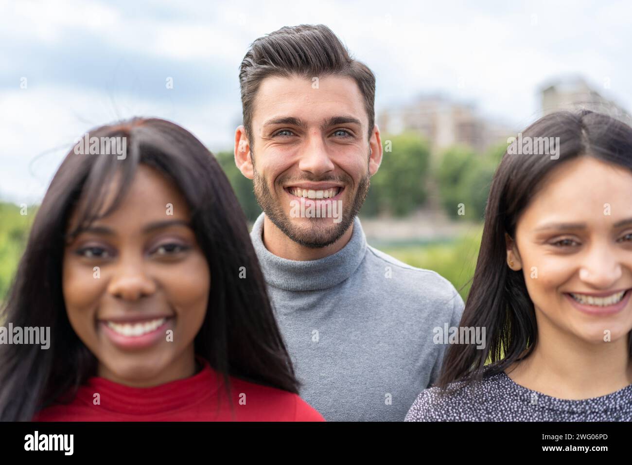 A diverse group of friends sharing a joyful moment in an urban park ...