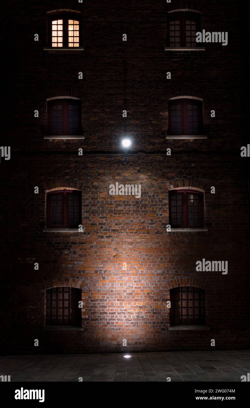 Illuminated Victorian brick warehouse windows at the historic docks at ...