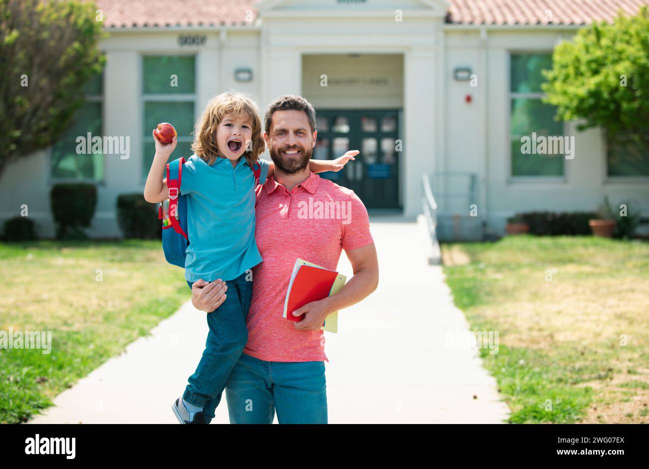 Father leads a little child school boy in first grade. Father supports ...