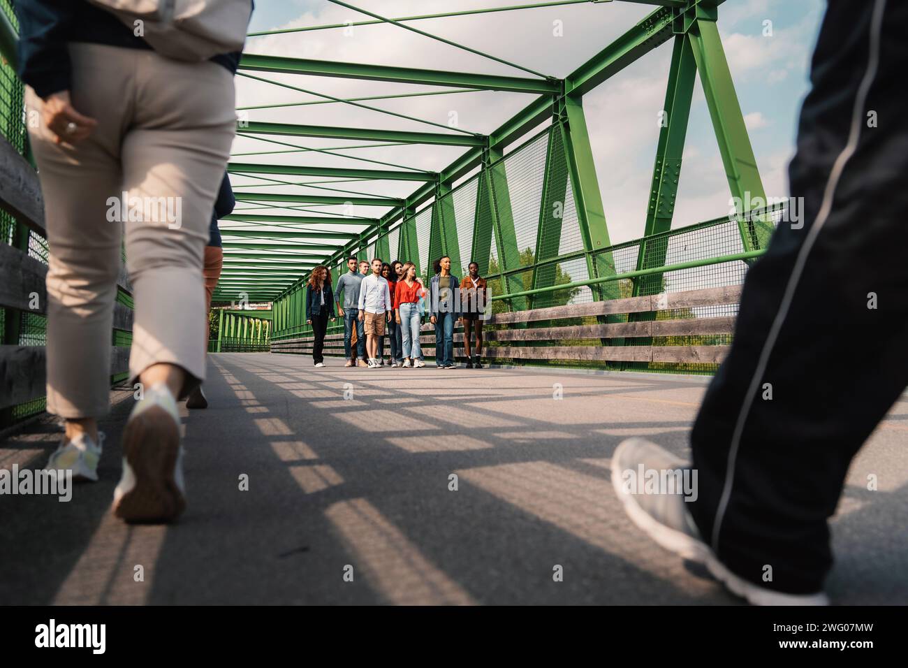 Multicultural group walking on an urban bridge, enjoying a leisure day ...