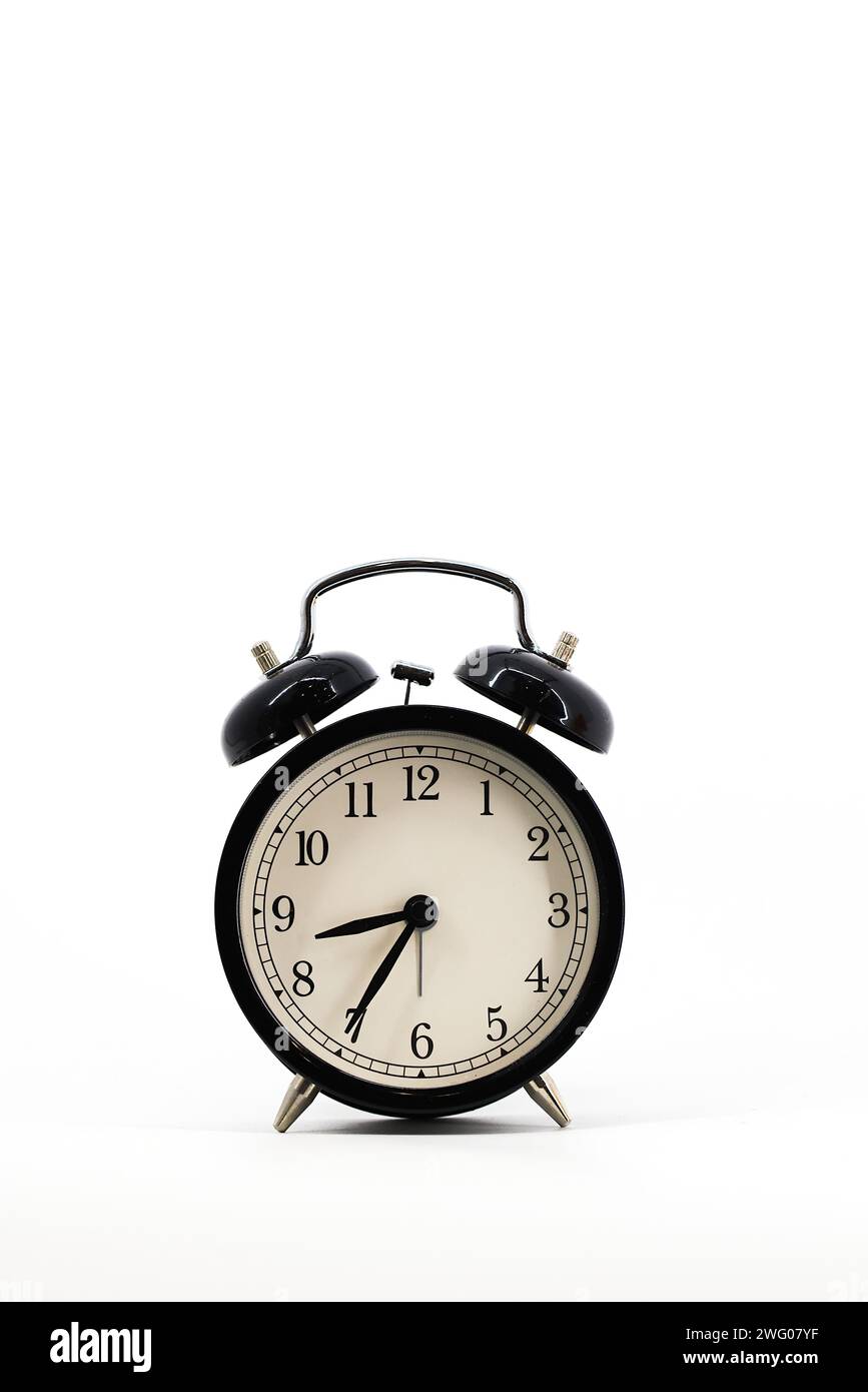 A black alarm clock featuring two bells on top, chrome handle, and legs ...