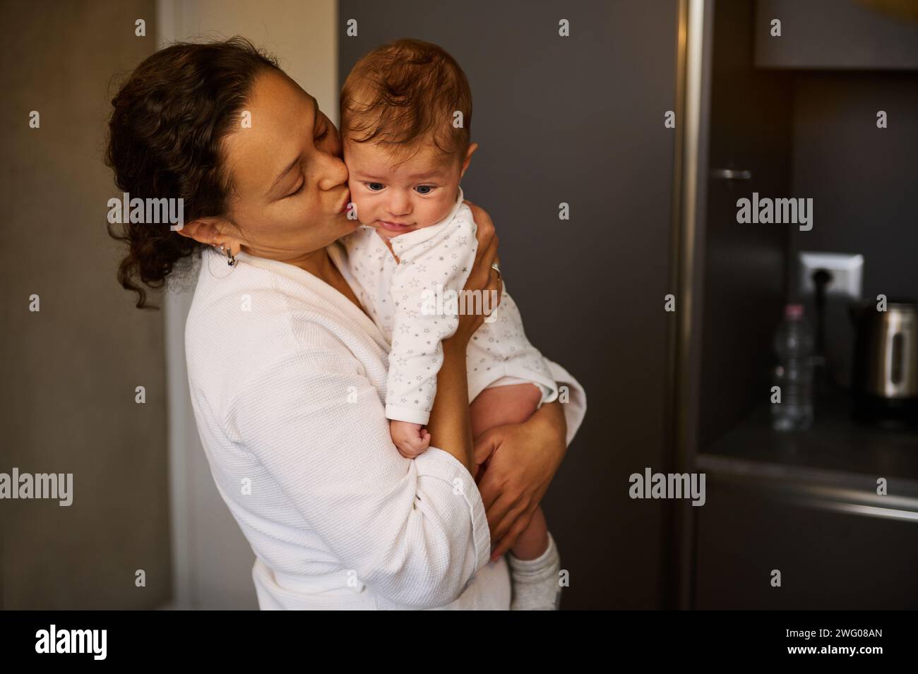 Beautiful young woman, a loving mother hugging her little baby boy at home. . Loving caring mom ...