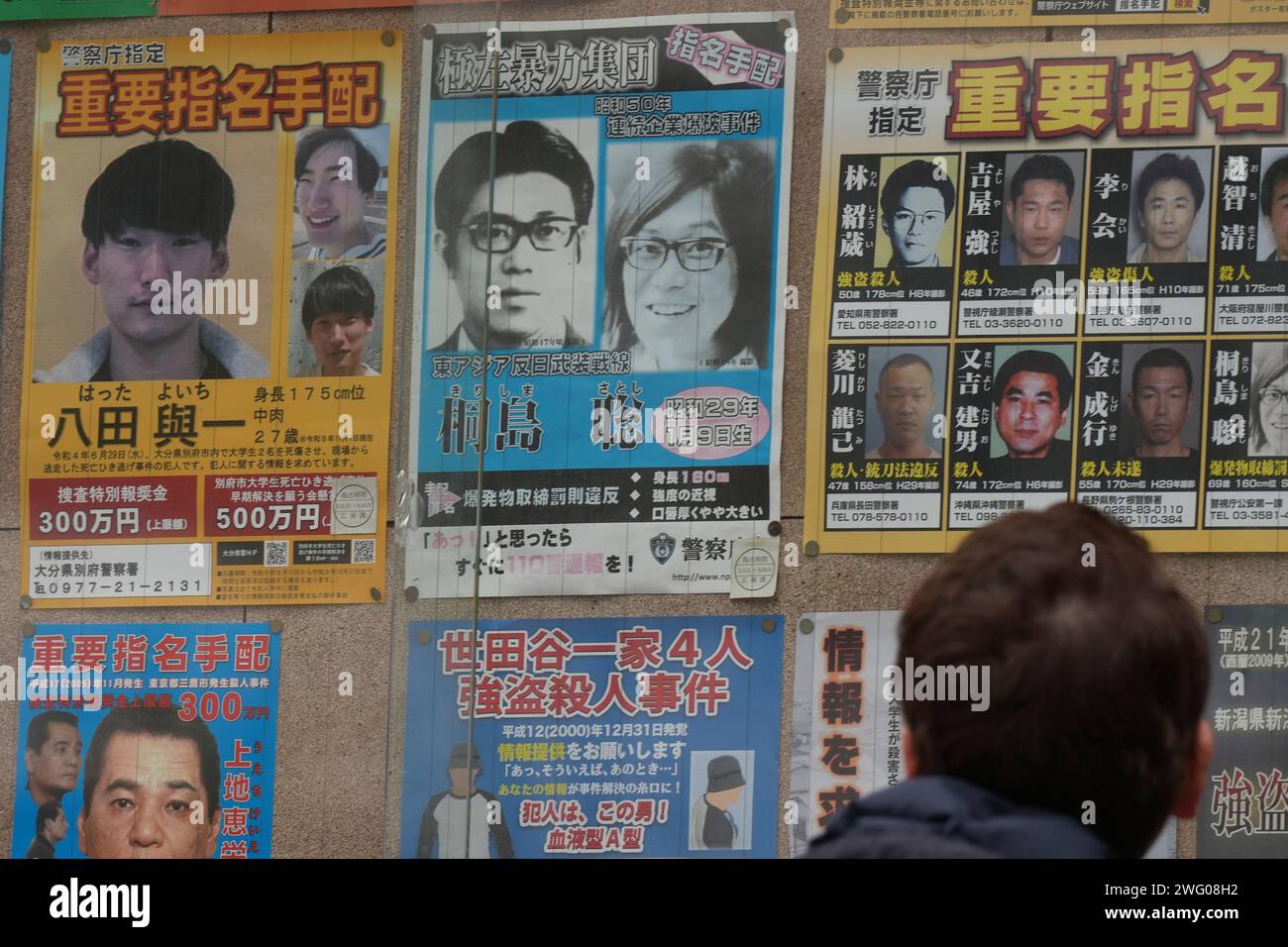 A wanted poster, center top. for Satoshi Kirishima, a fugitive who has ...
