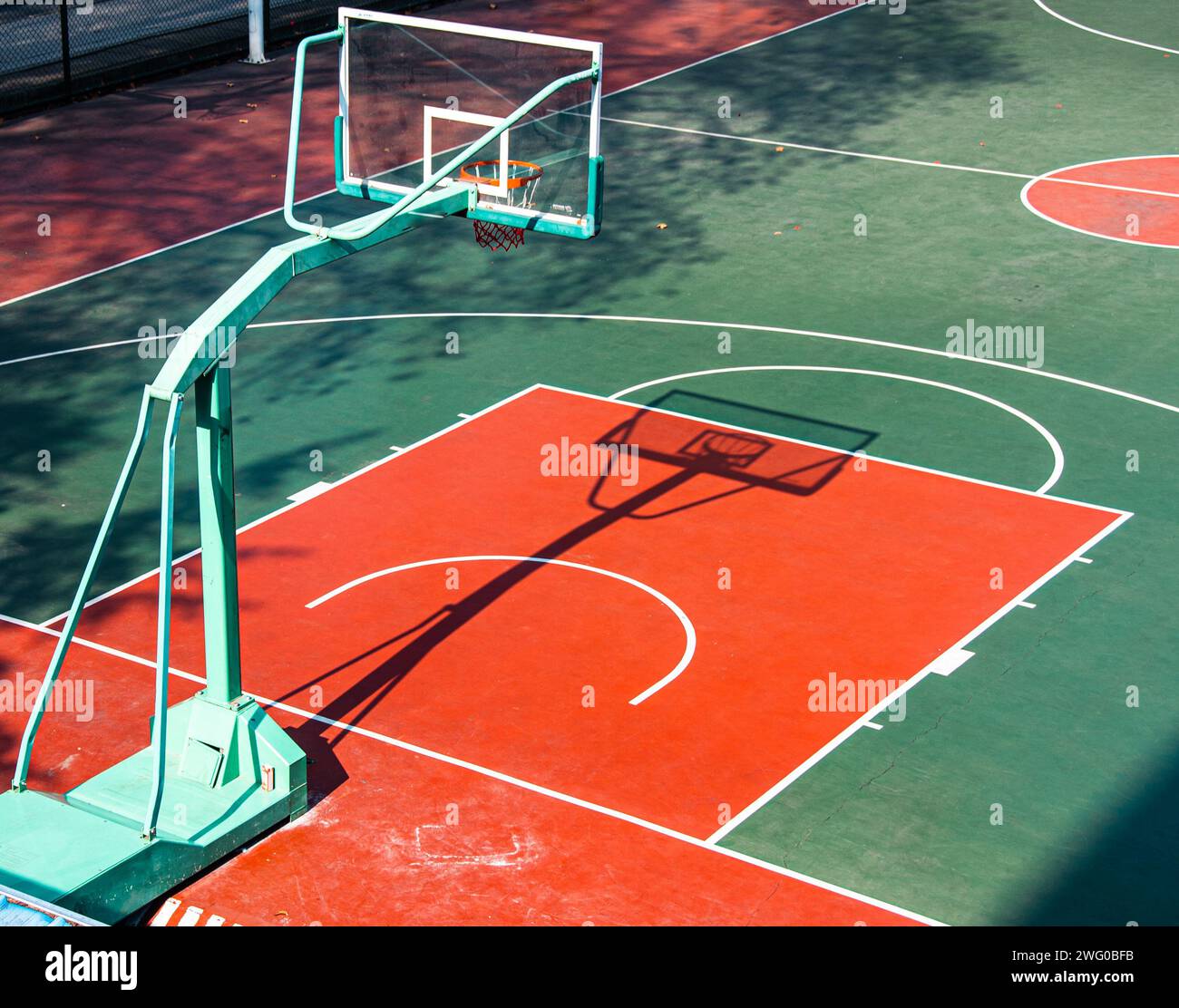 The open college basketball court, with bright colors, is illuminated ...