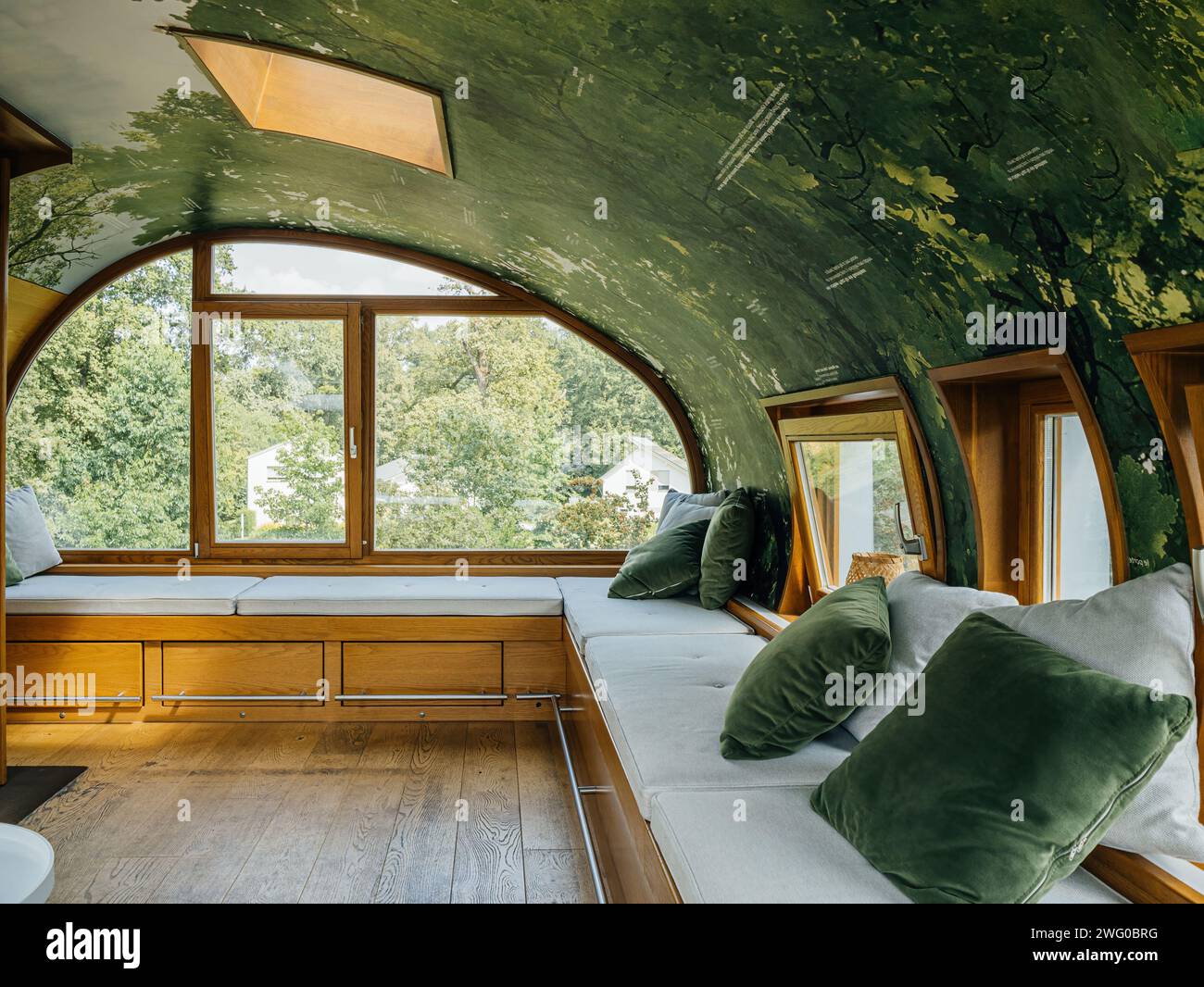 Modern treehouse interior with large windows, comfortable cushions, and ...