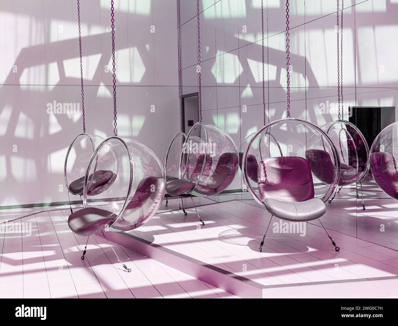 Transparent bubble chairs hanging from the ceiling in a modern, bright ...