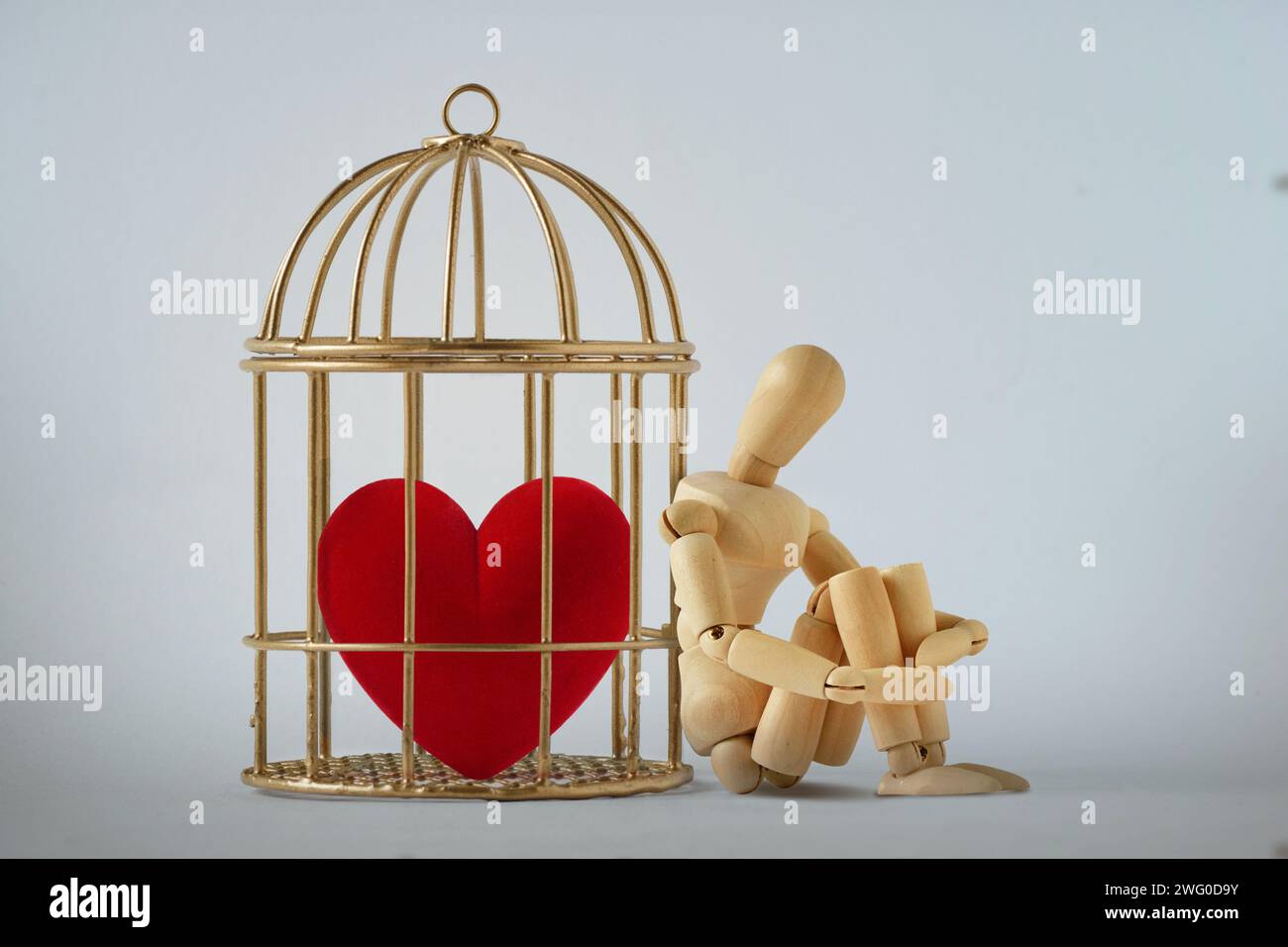 Heart in a bird cage and wooden mannequin - Love and closed heart ...
