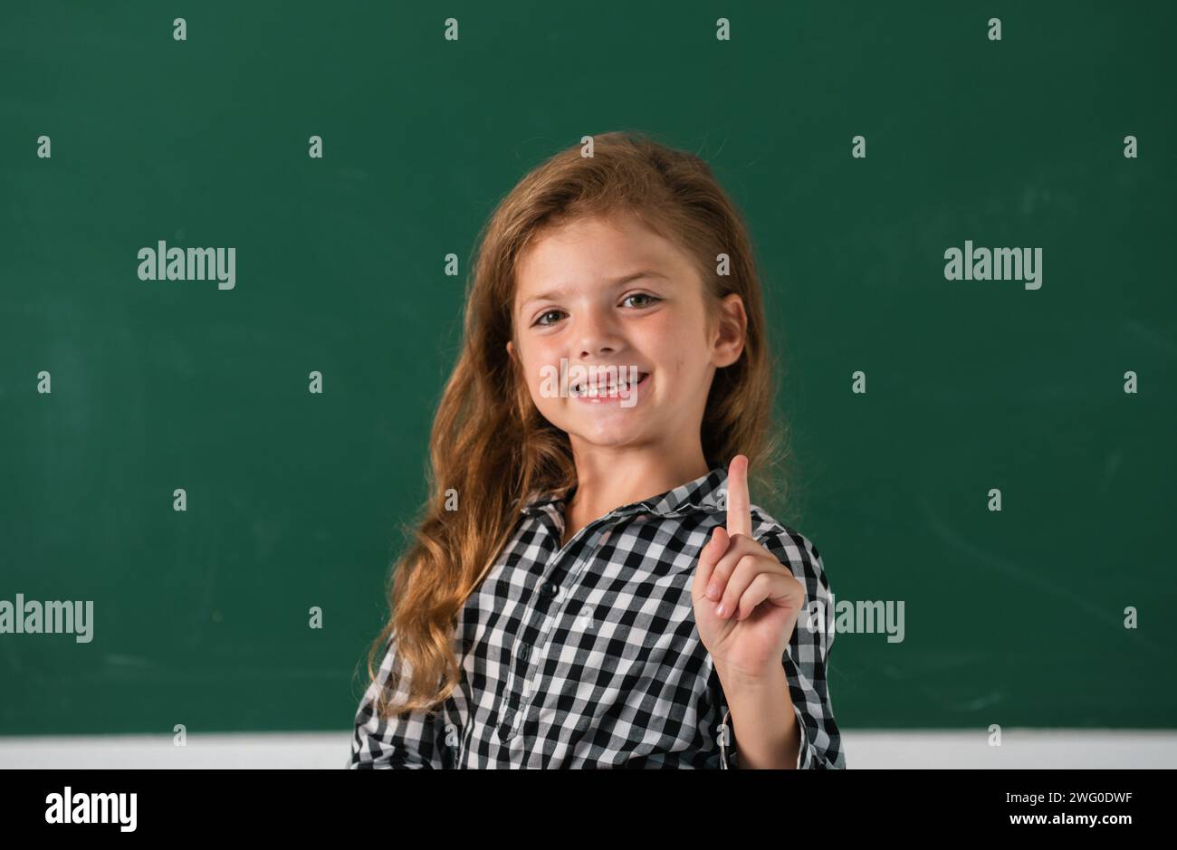 Portrait of school girl nerd pupil with surprising expression pointing ...