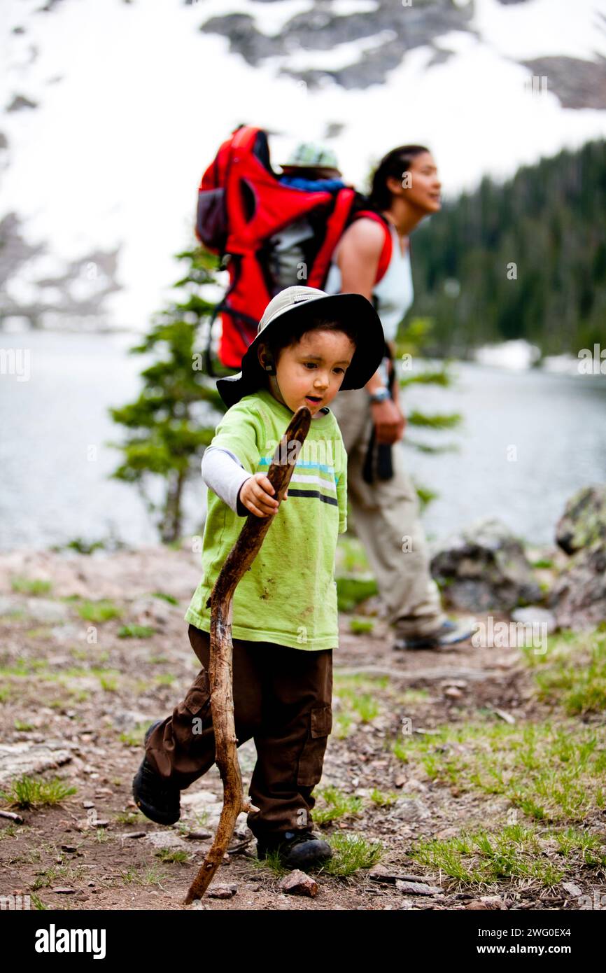 A mother carries her 6 month old son in a baby hiking backpack, while ...