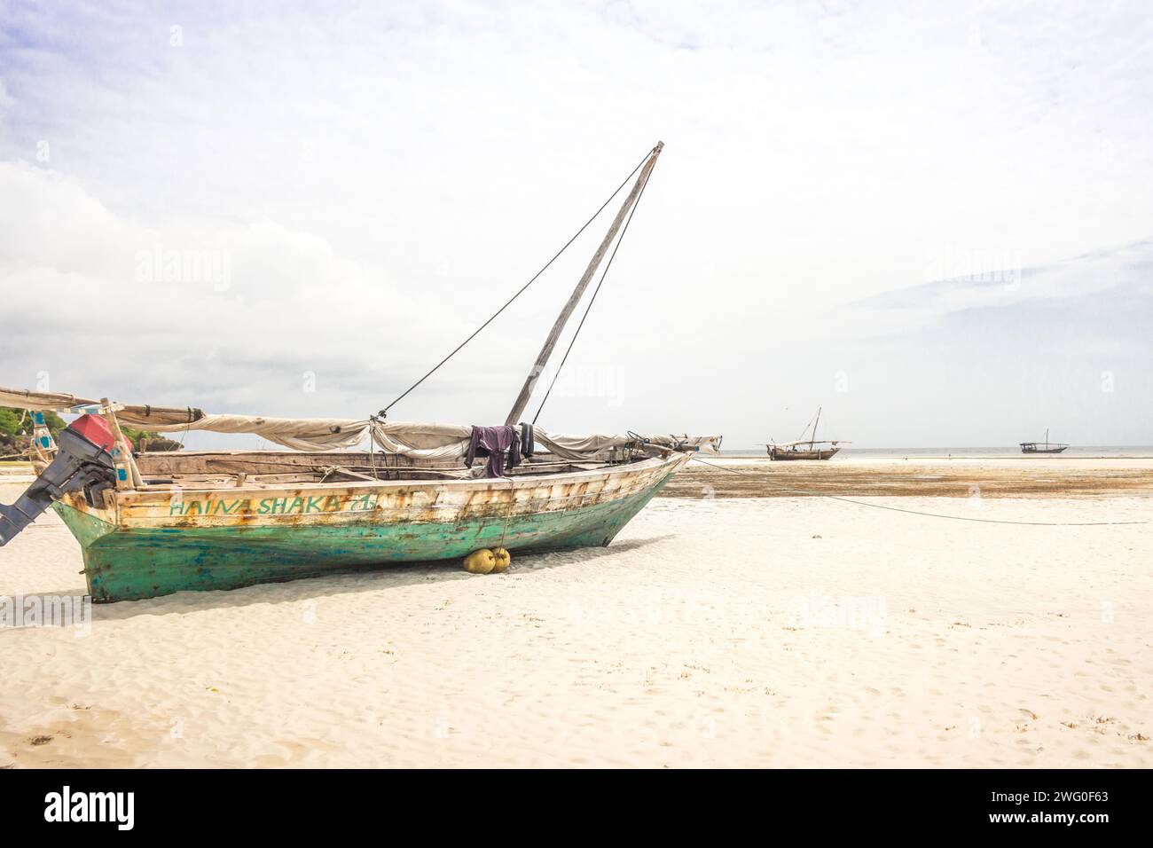 Rusty wooden boat anchored at the beach. Tropical low tide landscape ...