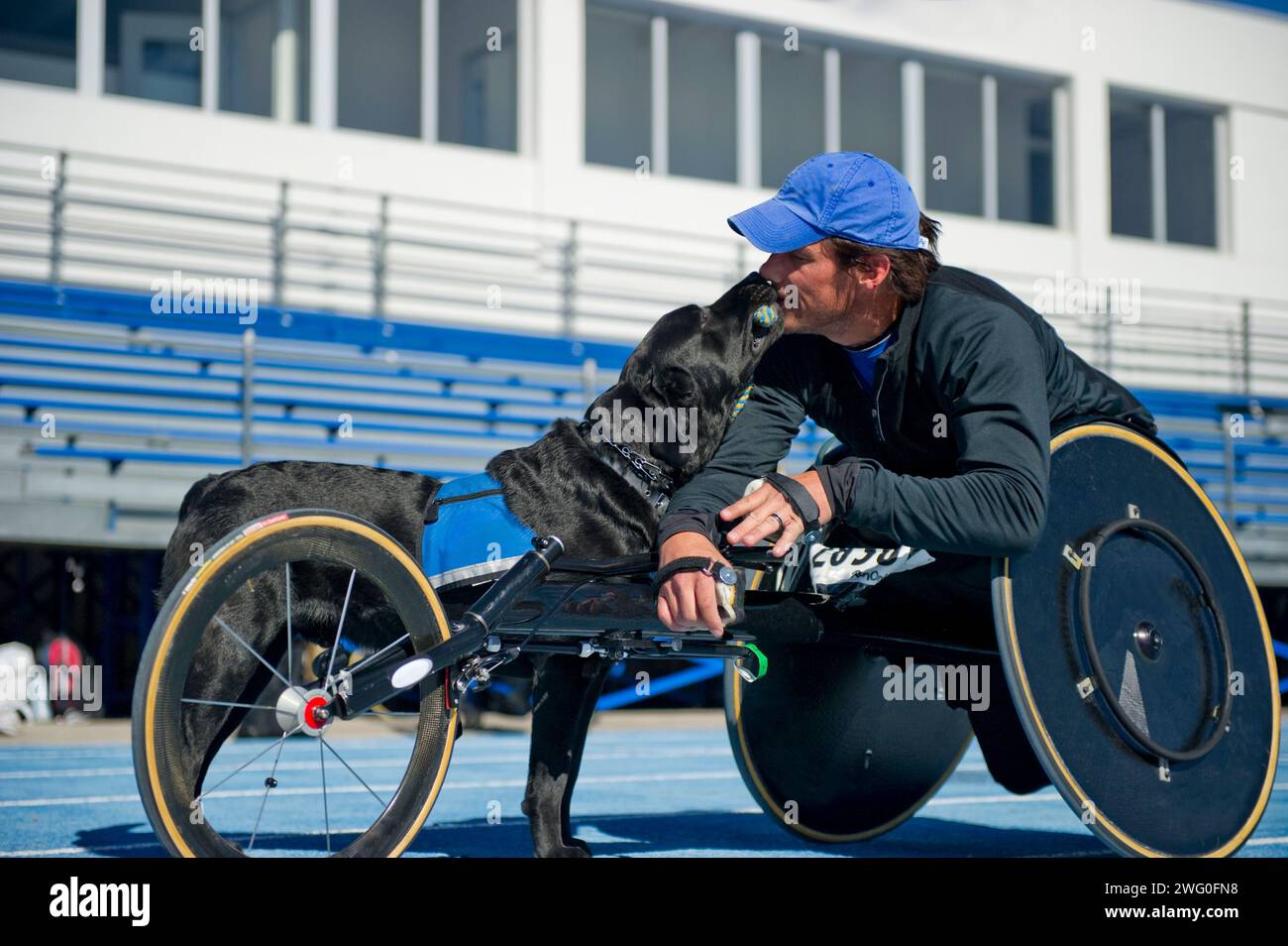 A wheelchair athlete bonds with his working dog after track practice ...
