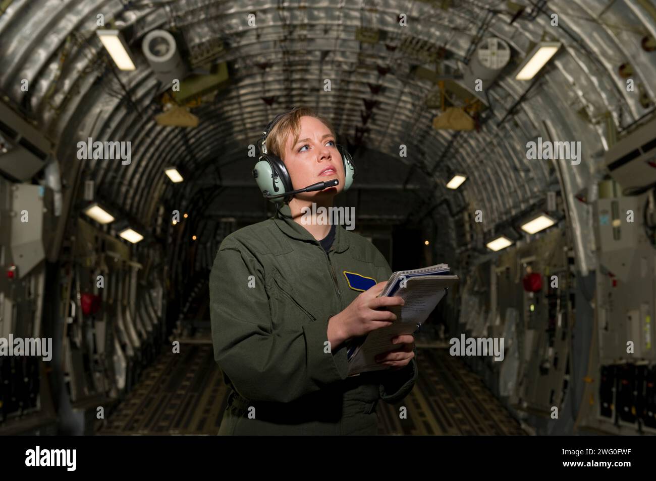 A U.S. Air Force loadmaster runs down her checklist in the cargo area ...
