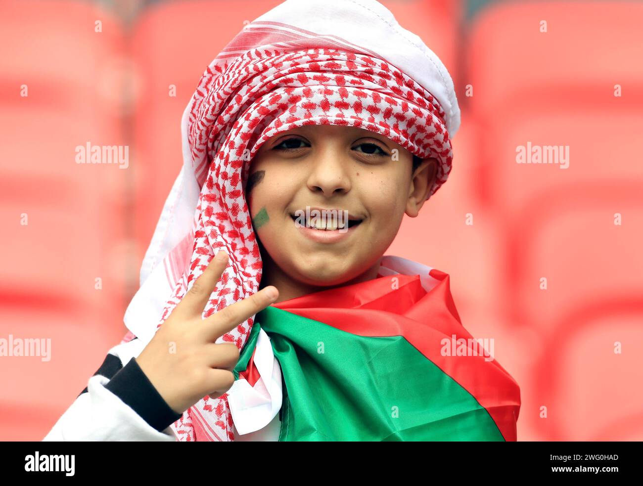 A Jordanian fan shows the victory sign during the quarterfinal soccer ...