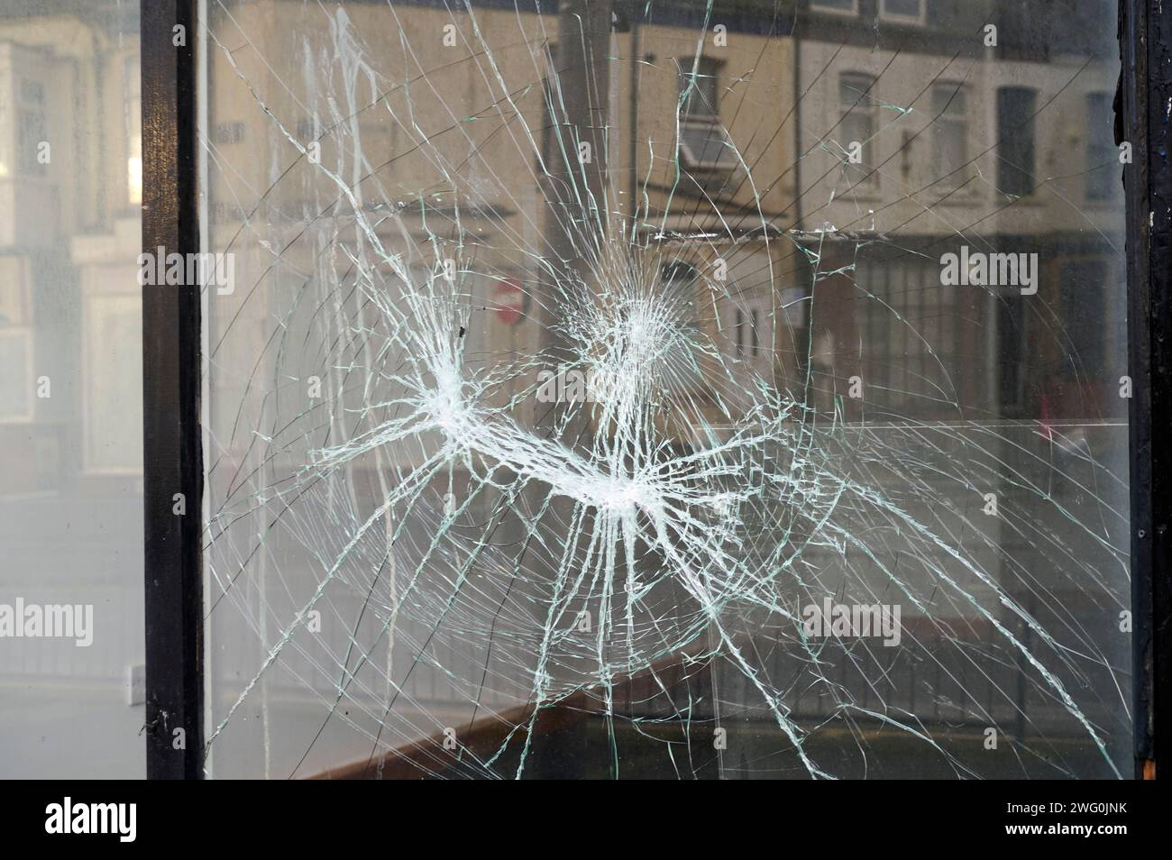 Cracked shop window with reflections of business premises showing Stock ...