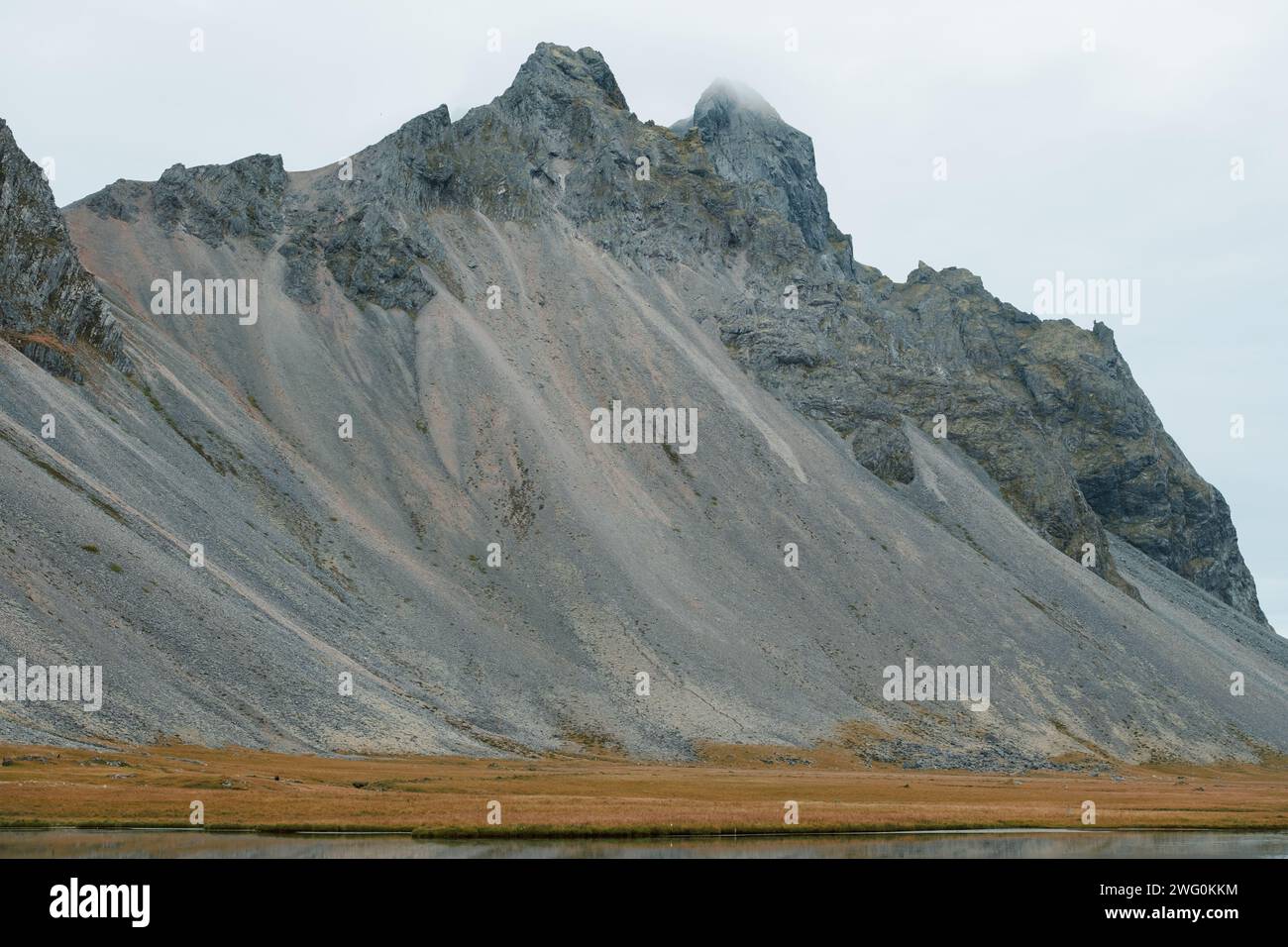 Scenic Iceland rocky mountain scape with cloudy sky and orange ground ...
