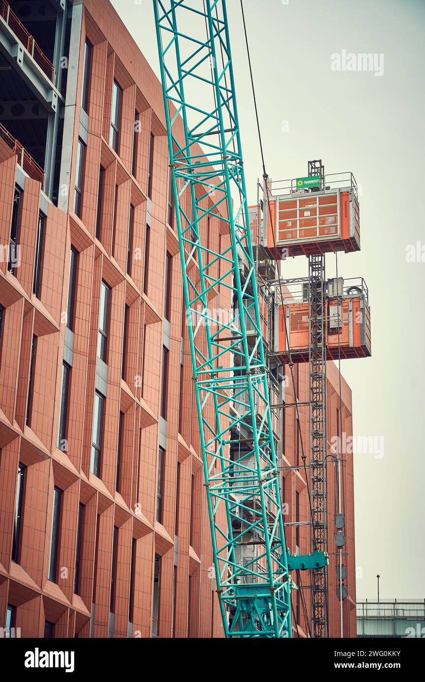 Hoists moving up and down side of building under construction Stock ...