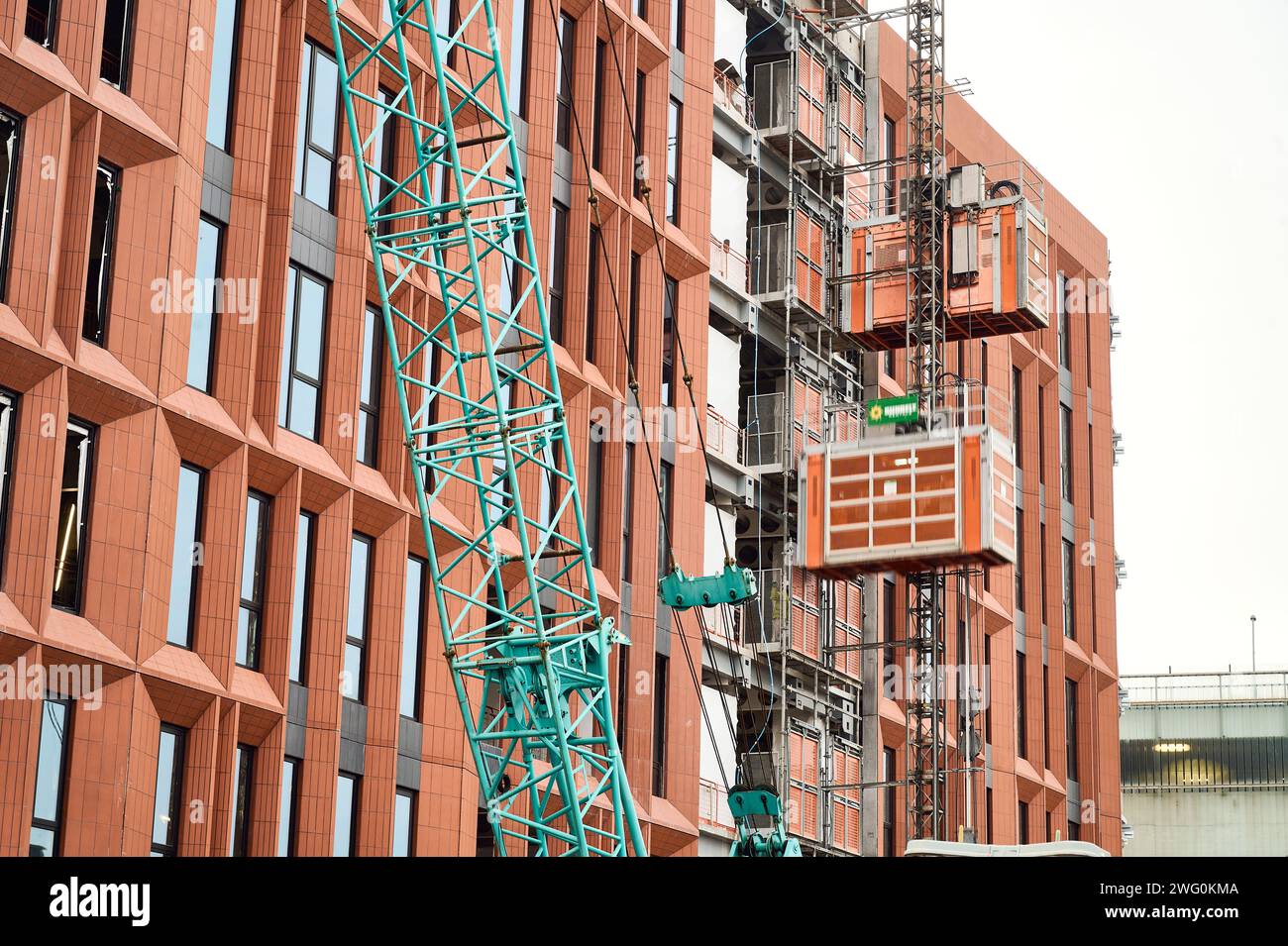 Hoists moving up and down side of building under construction Stock ...
