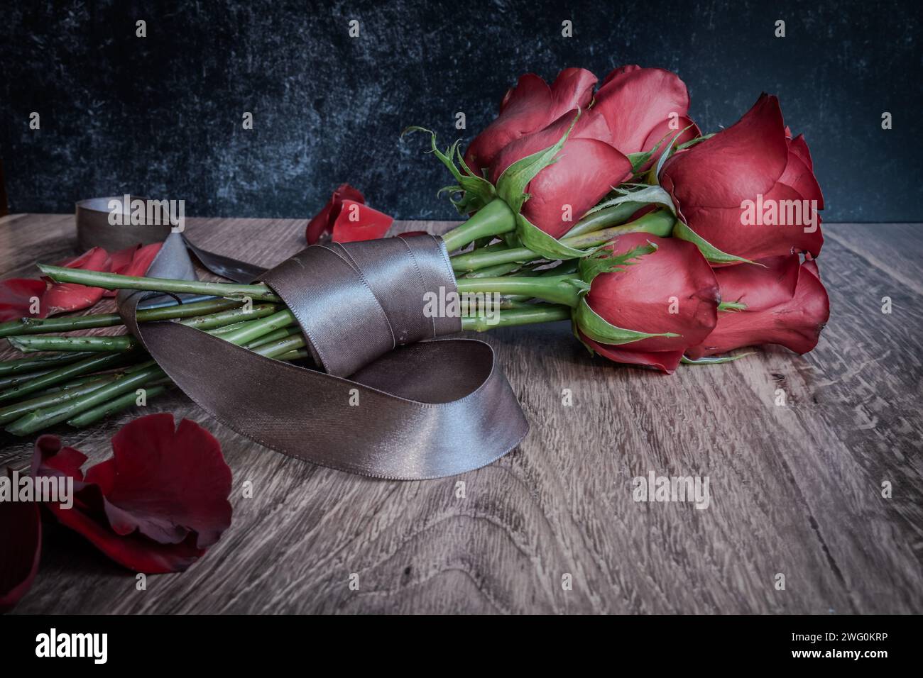 Bouquet of blooming red roses wrapped in gray ribbon Stock Photo - Alamy