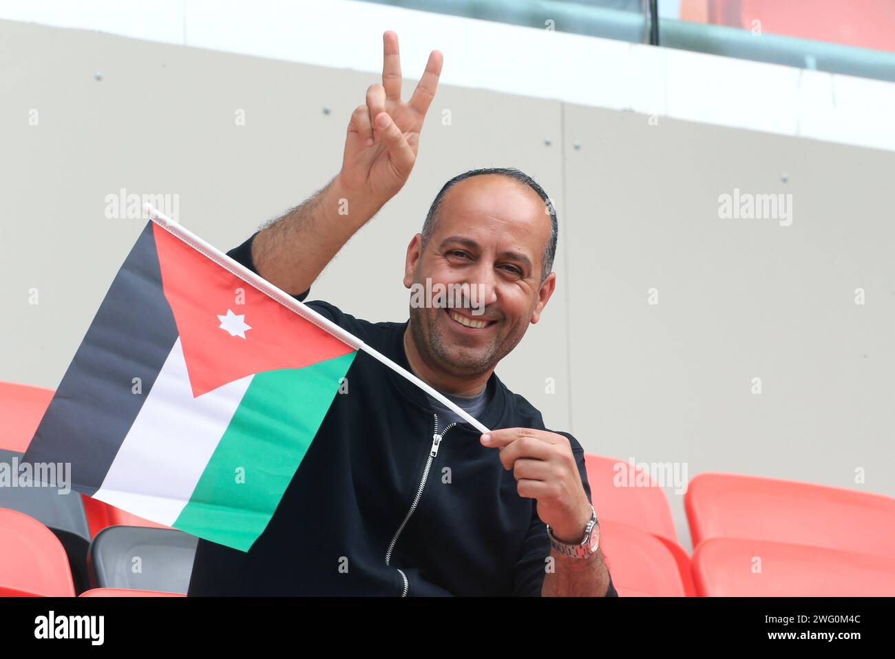 A Jordanian fan shows the victory sign during the quarterfinal soccer ...