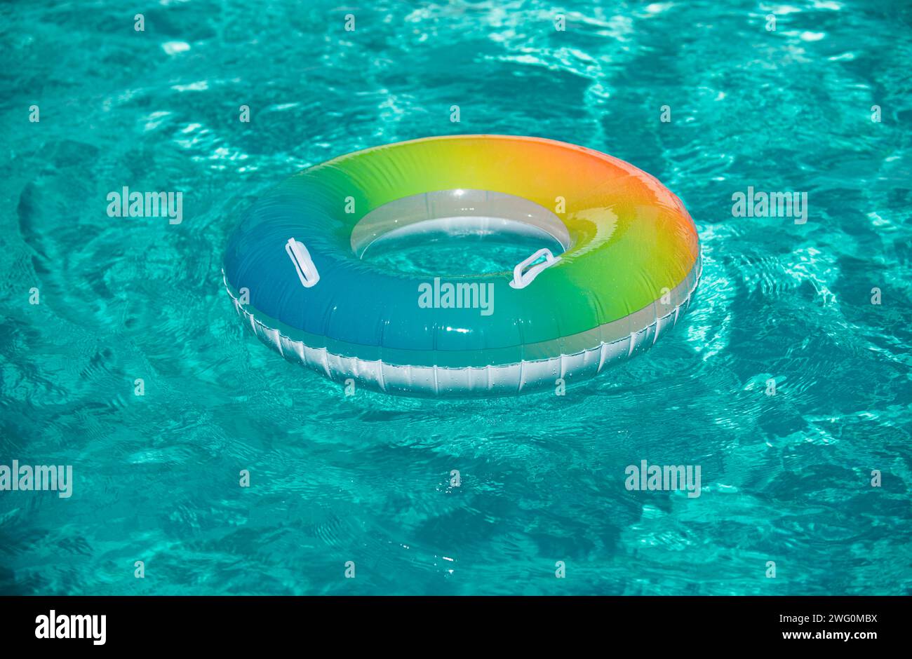 Pool float, rainbow ring floating in a refreshing blue swimming pool ...