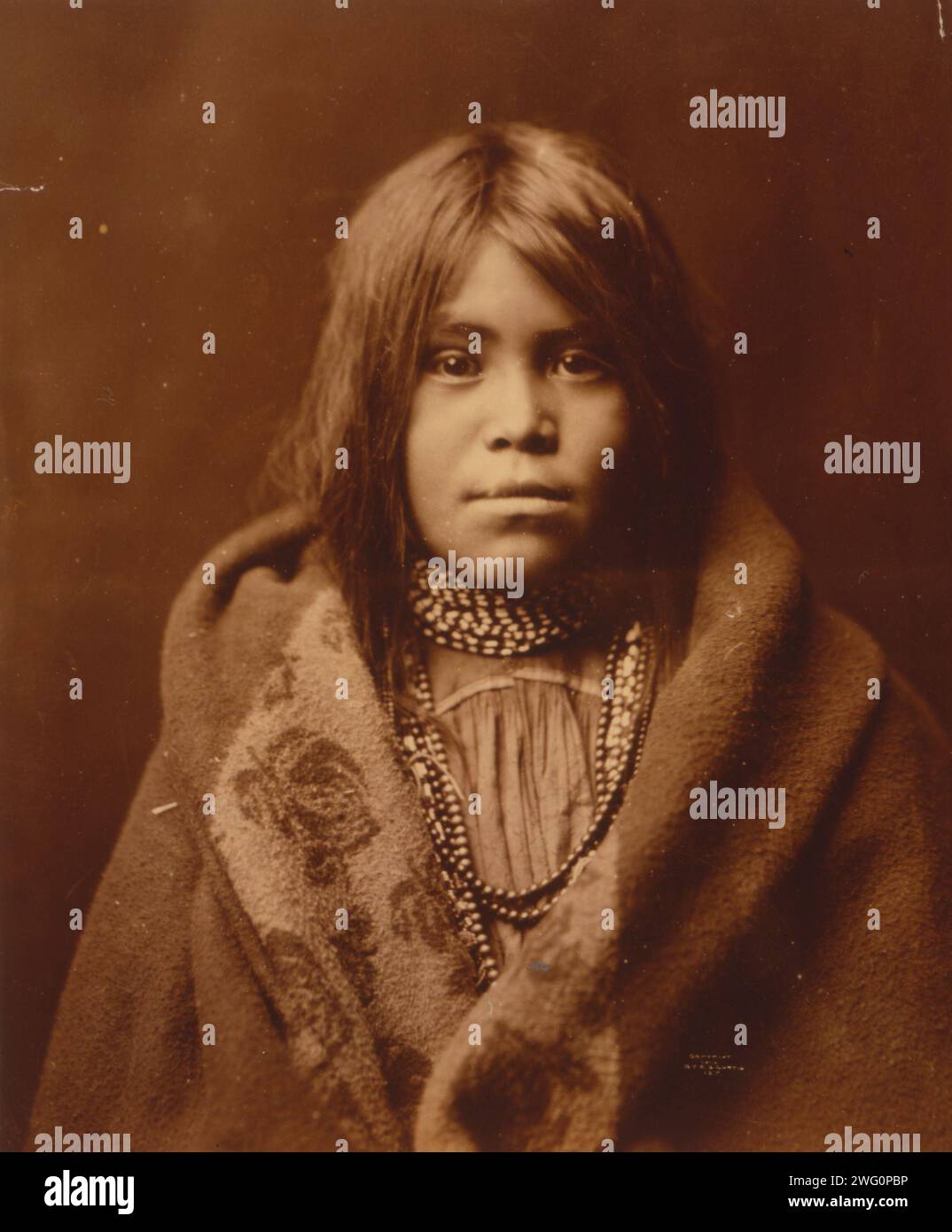 An Apache girl, head-and-shoulders portrait, facing front, wearing bead ...