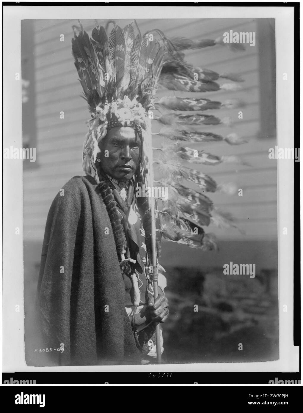 Piegan war-bonnet and coup-stick, c1910. Piegan man, half-length ...