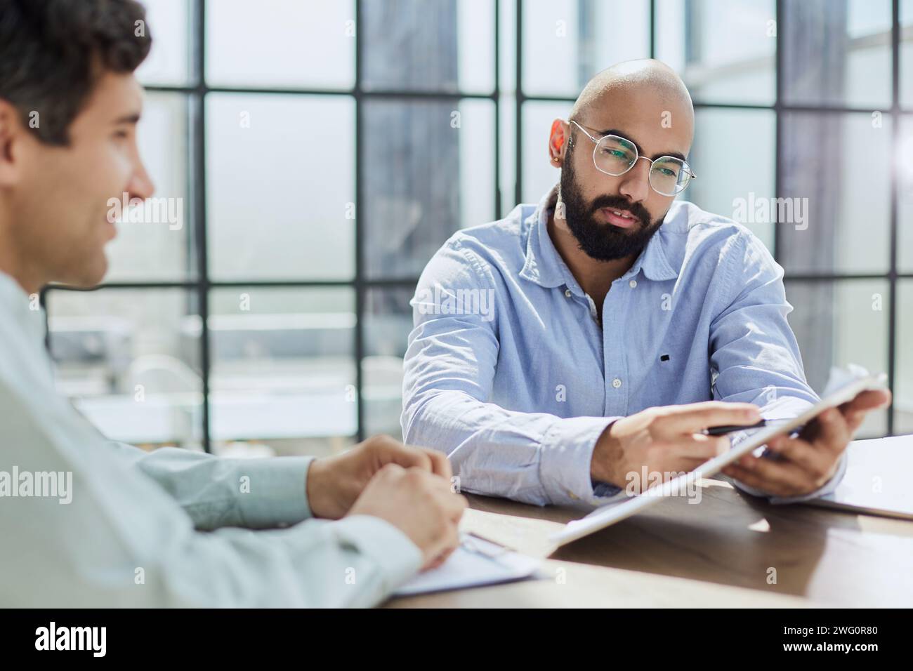 Startup partners discussing project at laptop, watching video ...