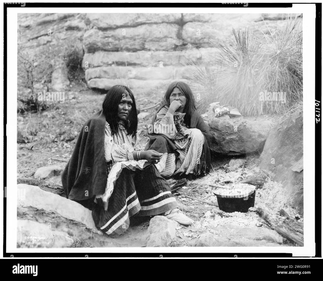 Two Apache Indian women at campfire, cooking pot in front of one, c1903 ...