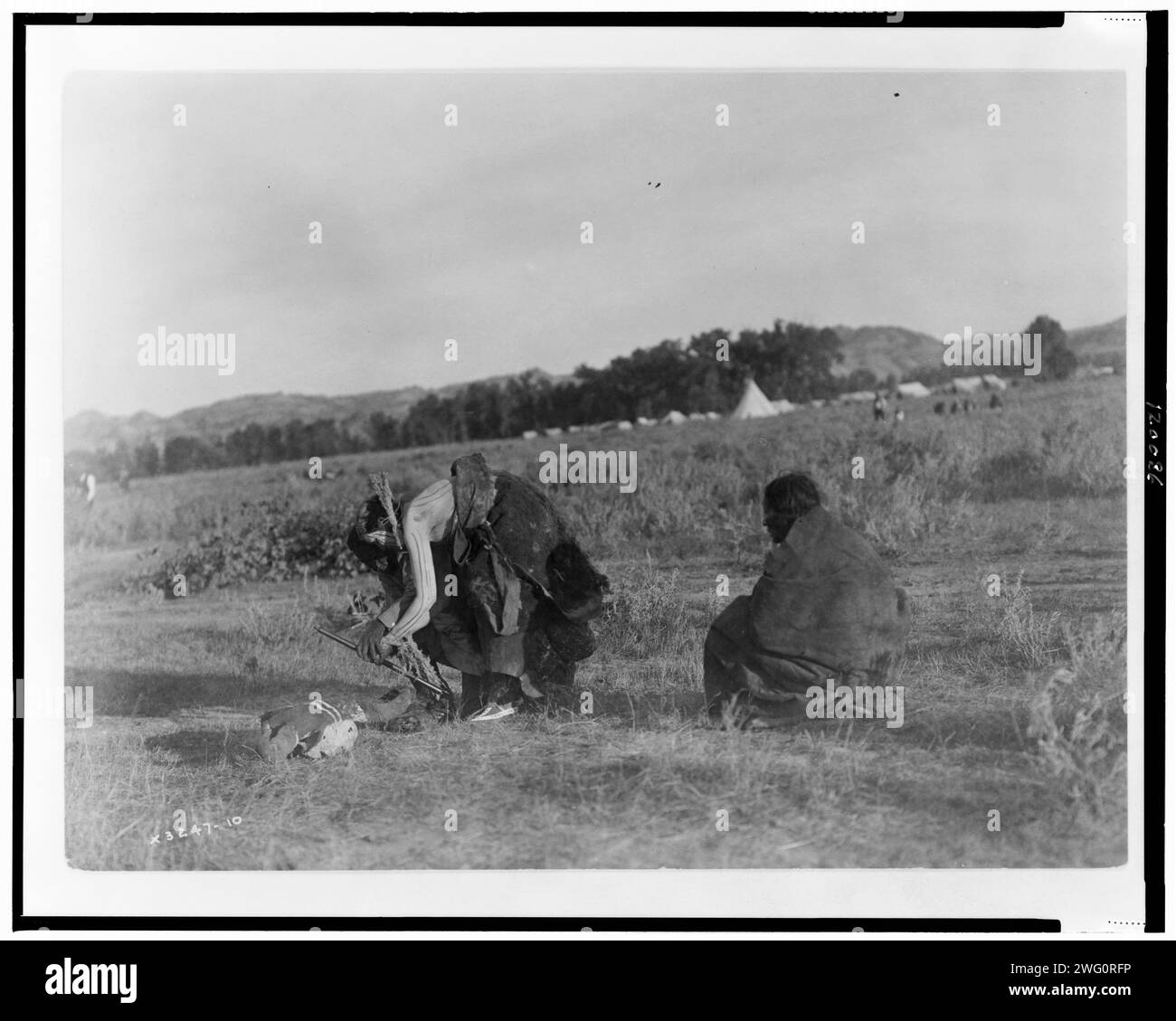 Offering pipe to the skull-Cheyenne, c1910. Woman offering pipe to ...