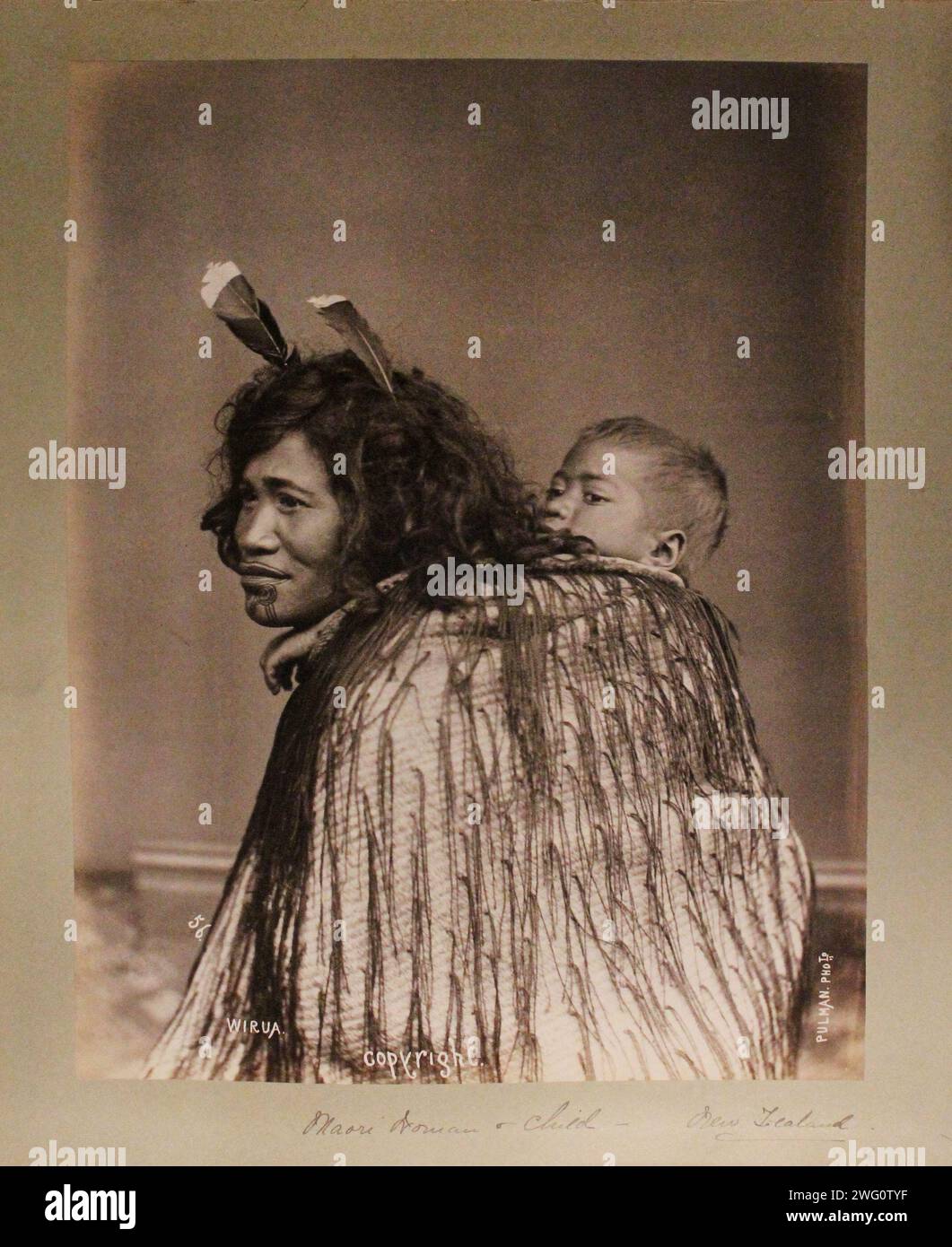 A Maori woman, Wirua, and child pose against a plain background. She ...