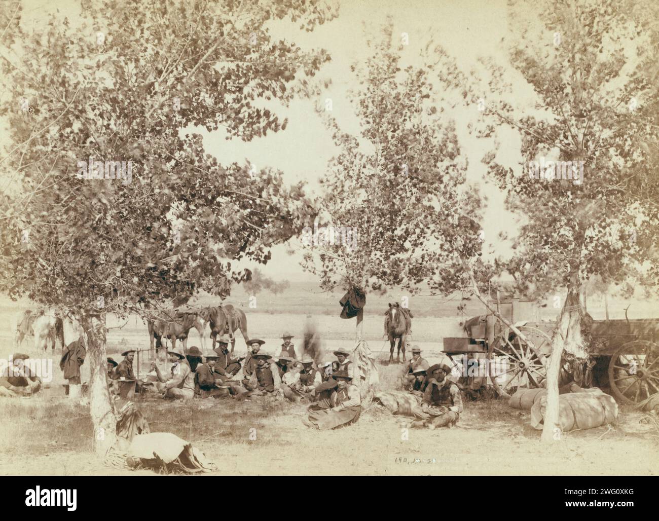 Dinner scene, between 1887 and 1892. Cowboys eating dinner, seated on ...