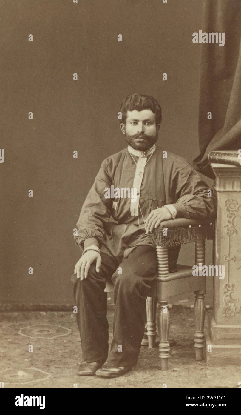 Full-length portrait of Armenian man, seated, facing front, between ...