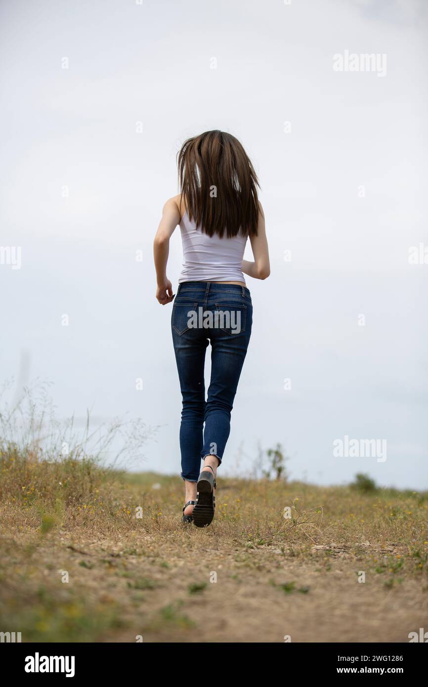 Woman running alone back view long hair hi-res stock photography and ...