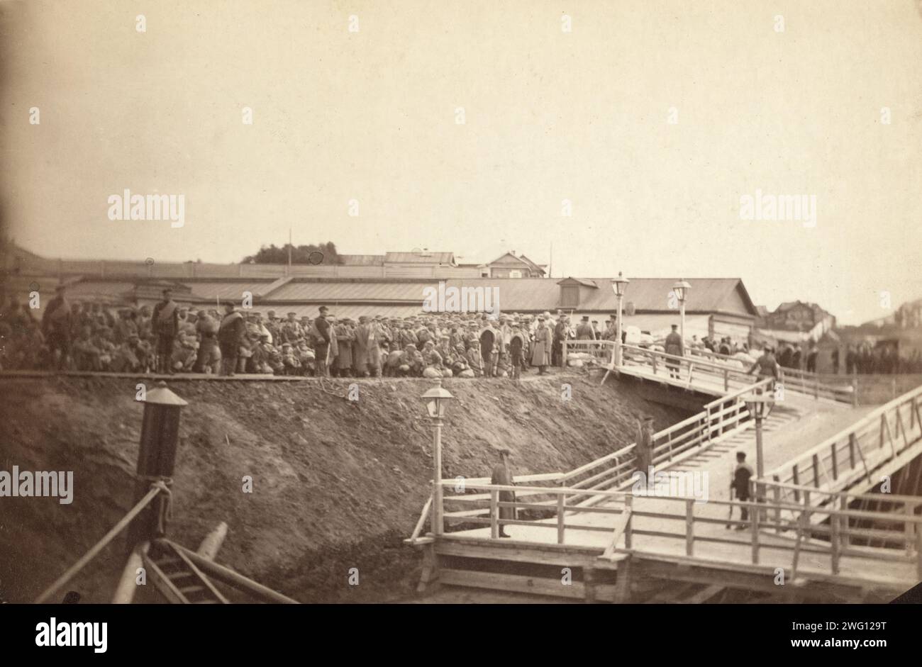 Group of convicts at head of inclined plane leading to barge, between ...