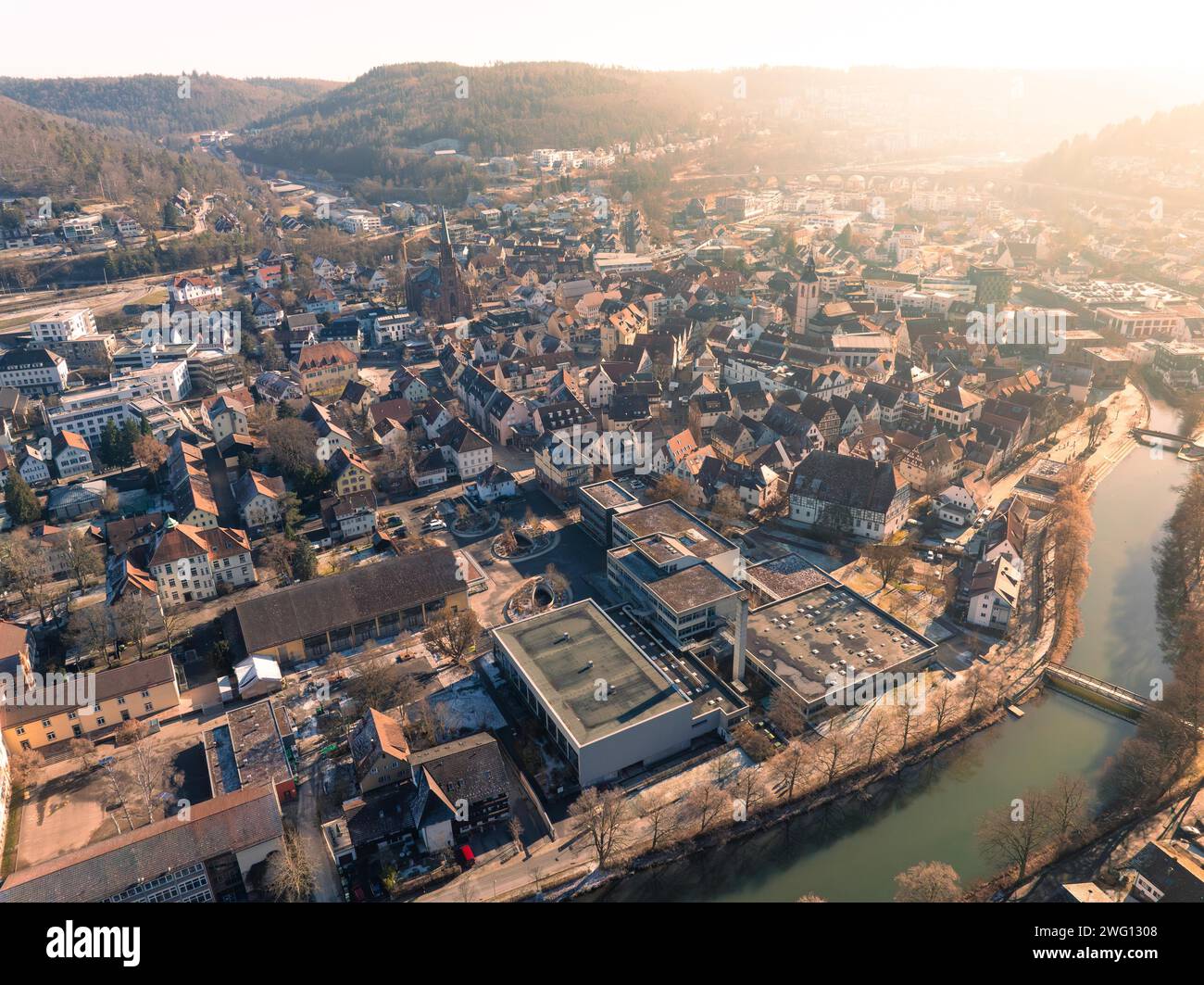 Aerial view of a town with river, wooded areas and a mixture of houses ...