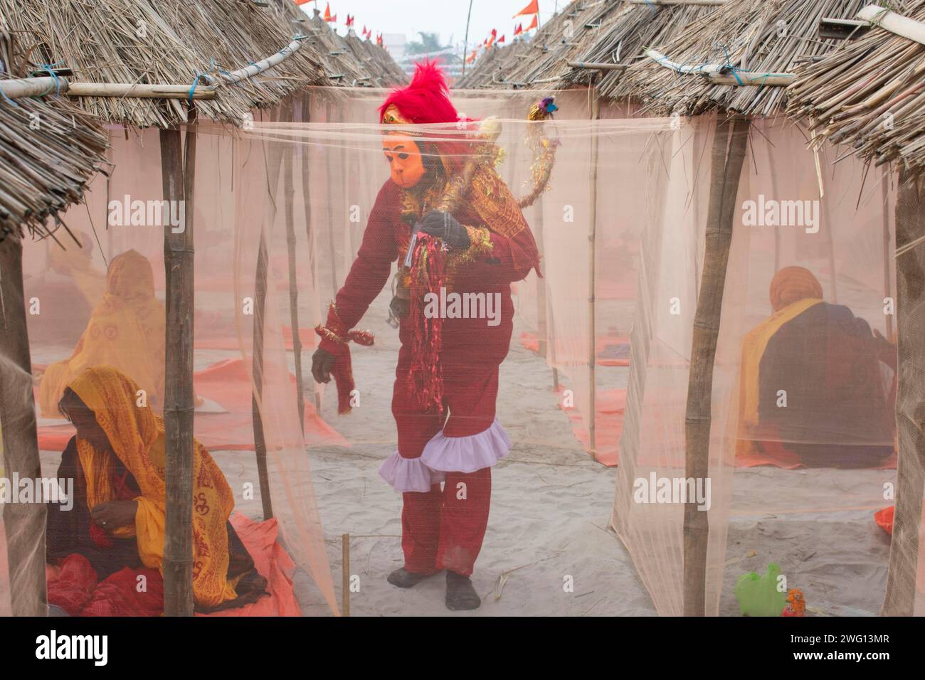 A devotee dressed as Hindu monkey-faced God Hanuman, standing next to ...