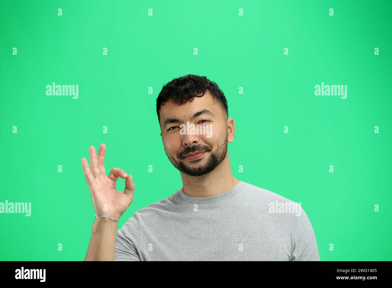 A man, on a green background, in close-up, shows an ok sign Stock Photo ...