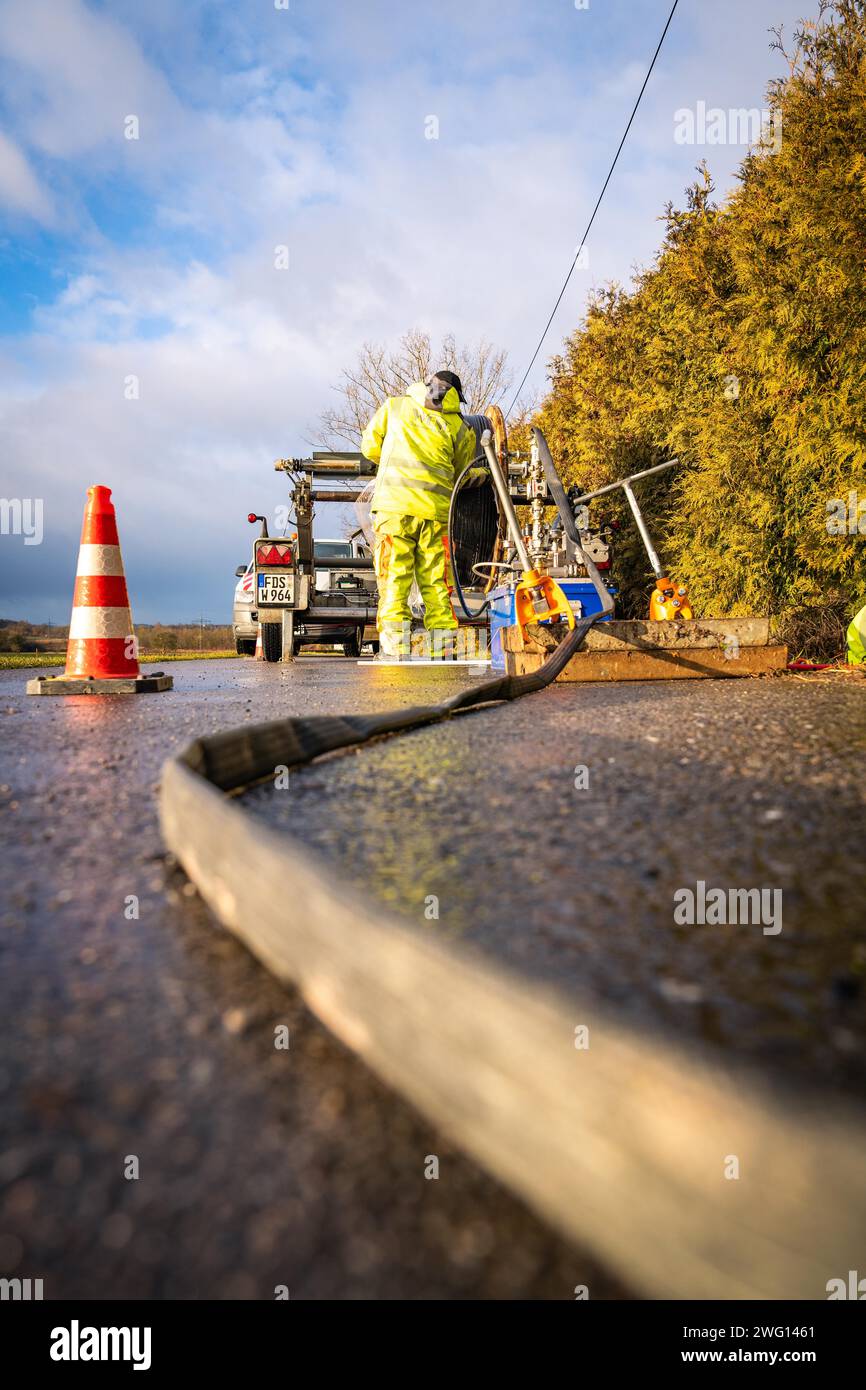 Worker prepares cable spool installation next to an emergency vehicle ...