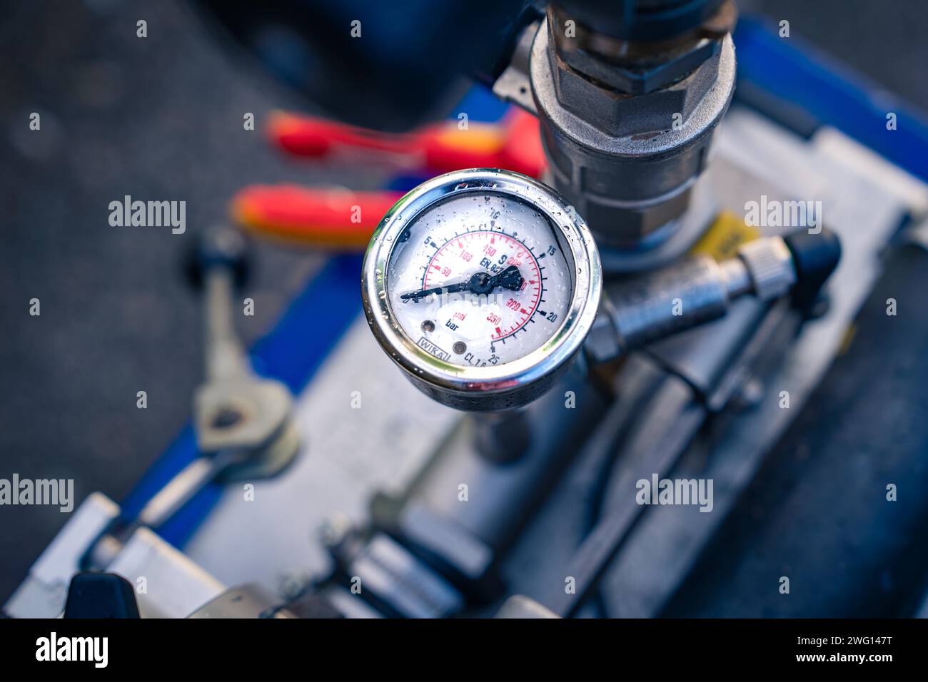 A detailed view of a round pressure gauge on a machine, glass fibre ...