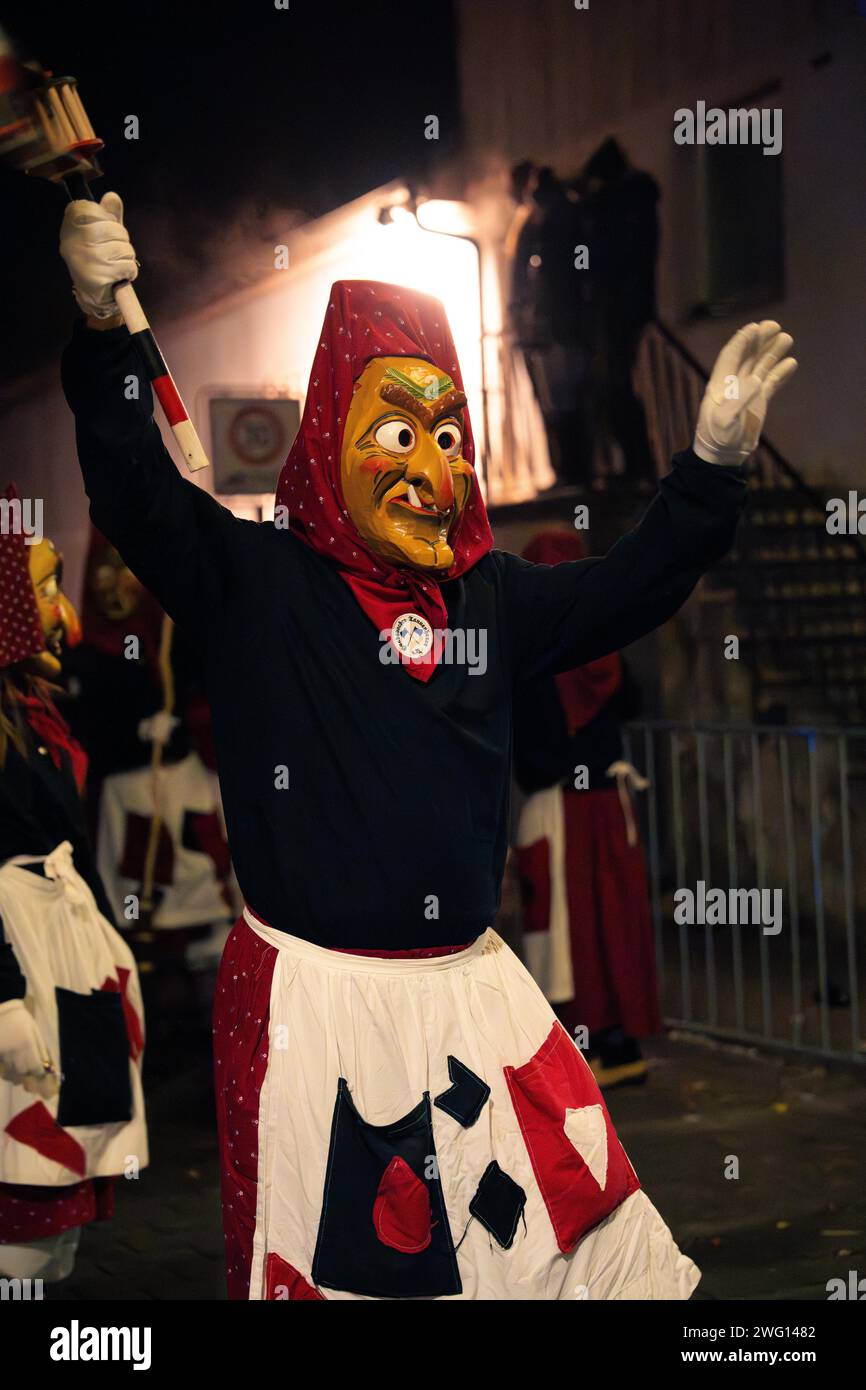 Fool figure with torch in hand celebrates carnival at night, carnival ...
