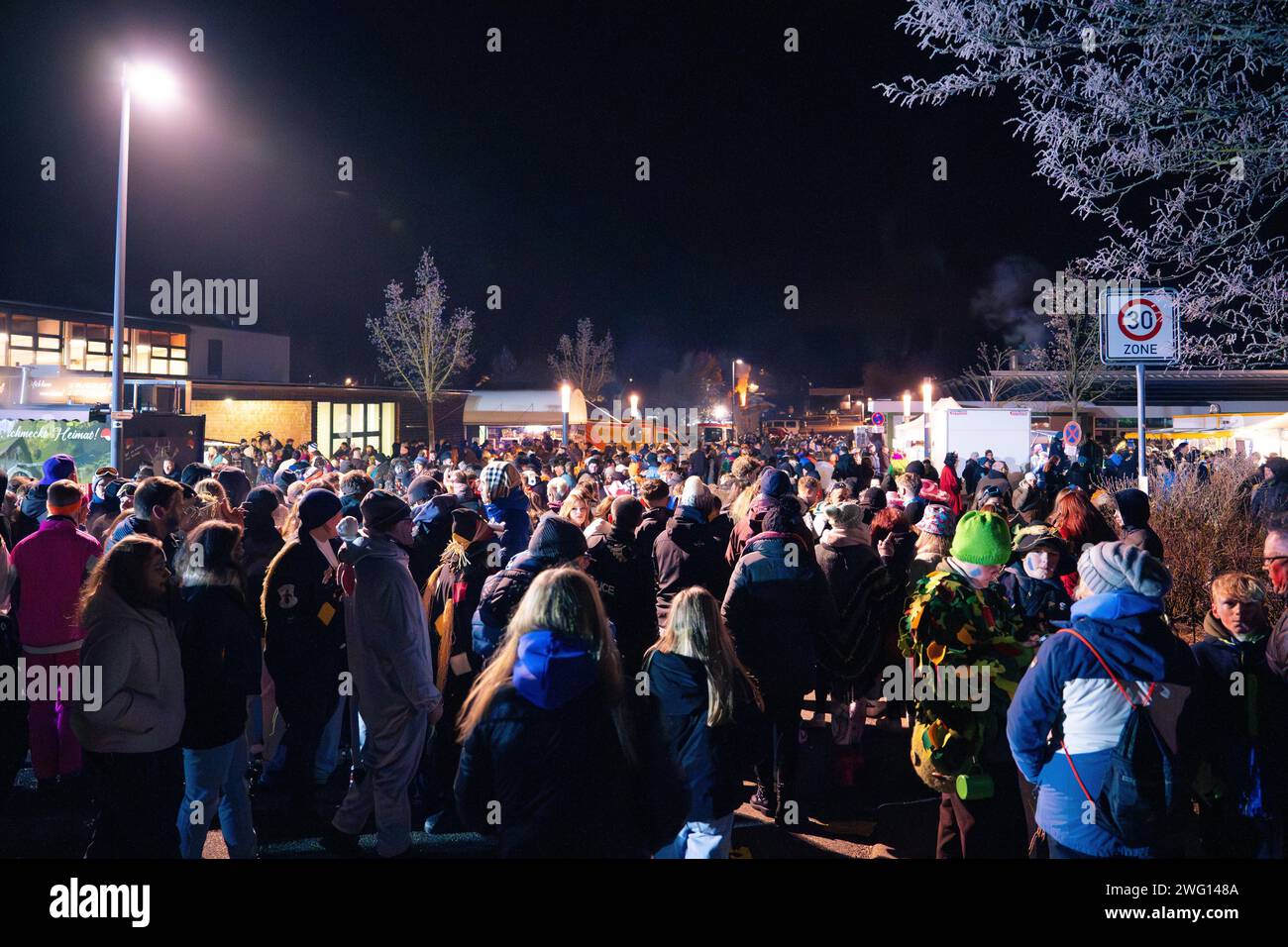 Crowd gathers outside at an evening carnival event, carnival ...
