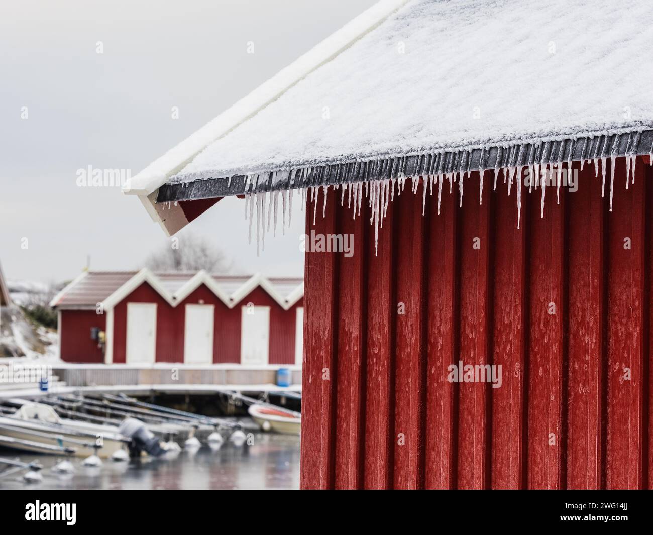 Icicles glisten as they hang from the edge of traditional red cabins ...