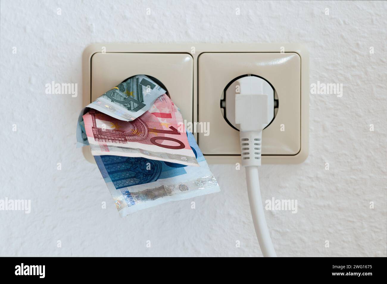 A white electrical outlet with Euro bills plugged into the socket next ...