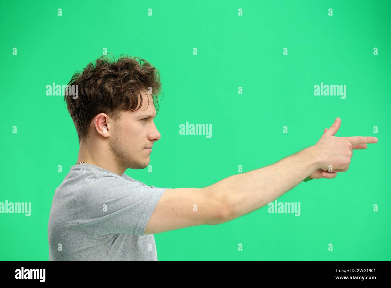 A man, on a green background, in close-up, points to the side Stock ...