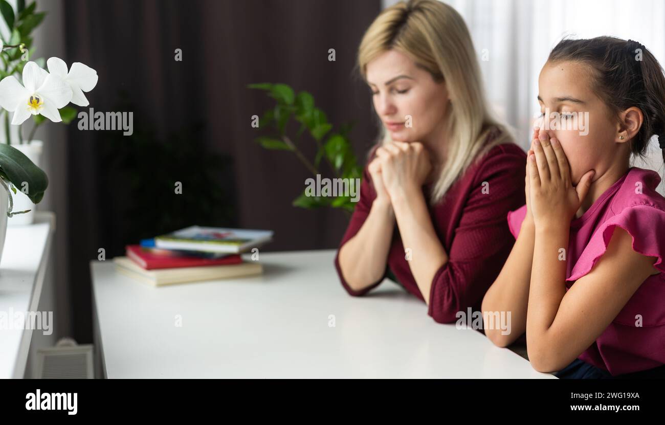 Religious Christian girl praying with her mother indoors Stock Photo ...